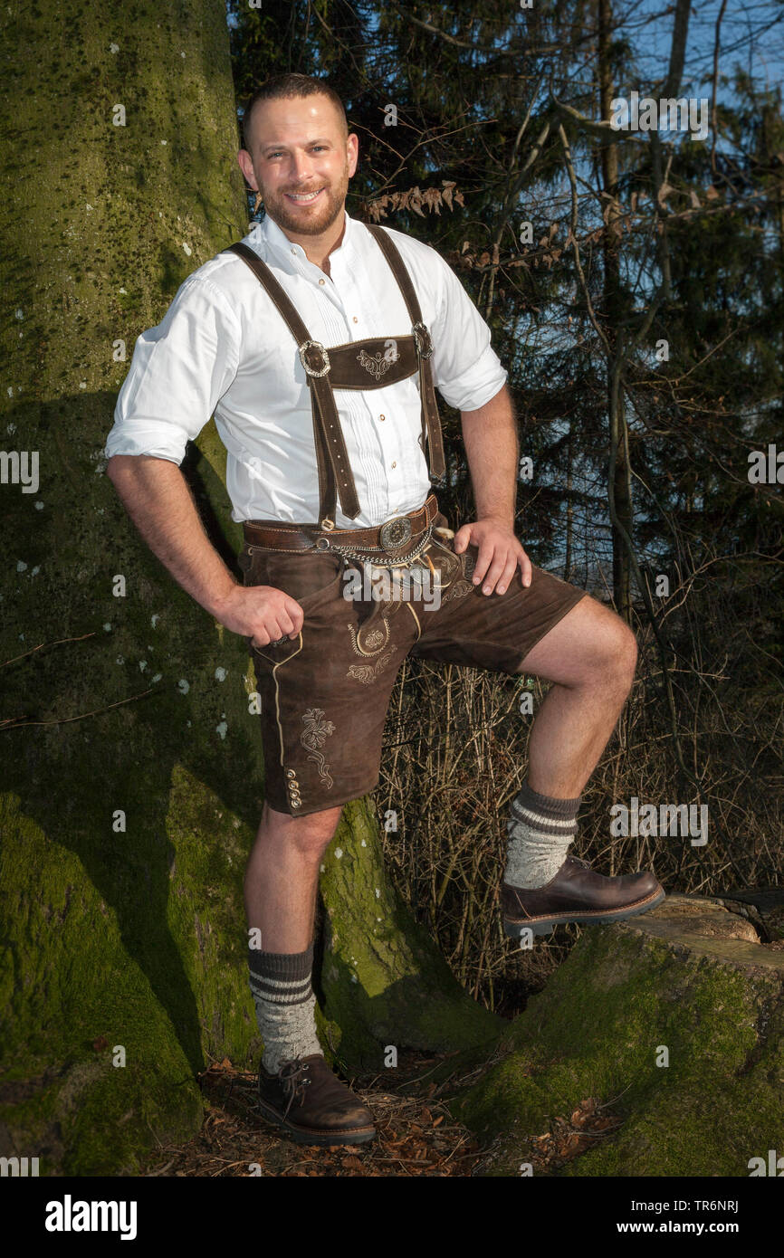 traditional clothed Bavarian man standing at a tree, Germany, Bavaria ...