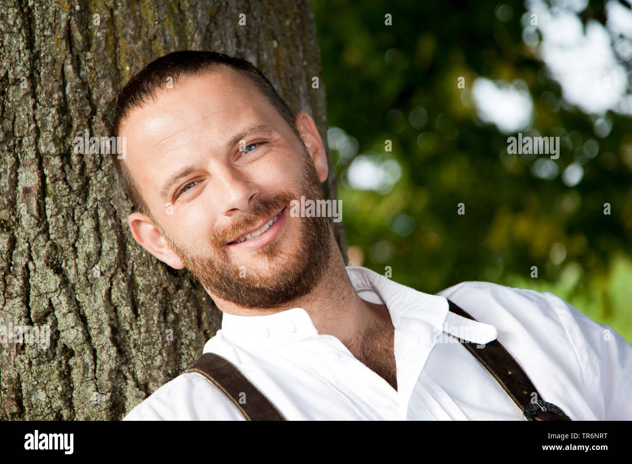 traditional clothed Bavarian man at a tree , Germany, Bavaria Stock ...
