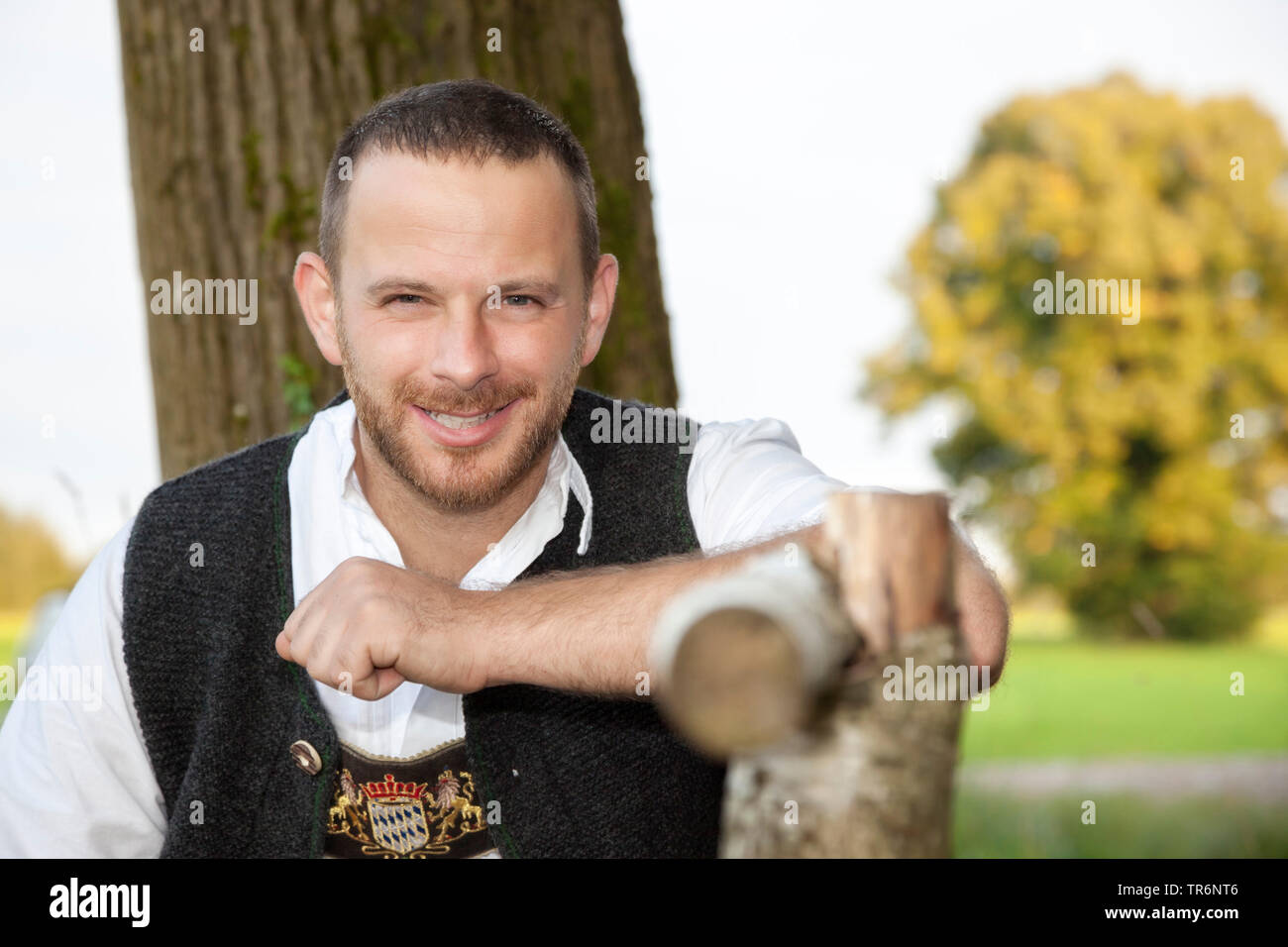 traditional clothed Bavarian man sitting on a bench, Germany, Bavaria ...
