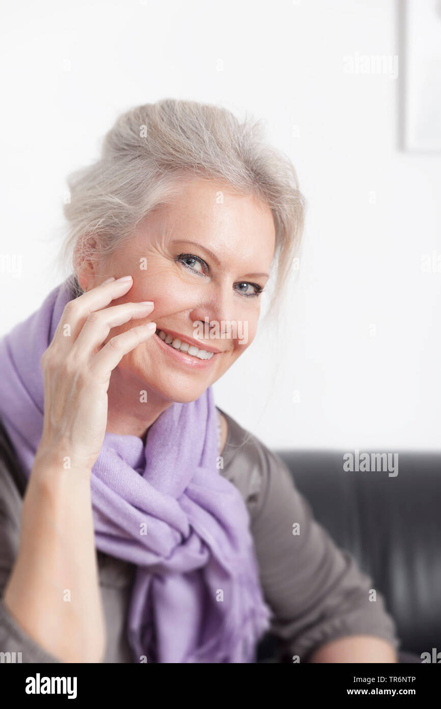 female senior sitting contentedly on a sofa, portrait, Germany Stock ...