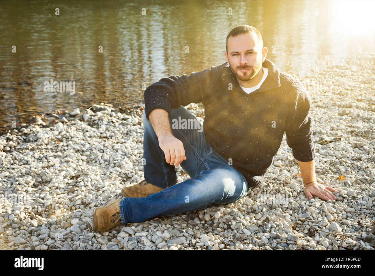 handsome man sitting by the waterside of a river, Germany Stock Photo ...