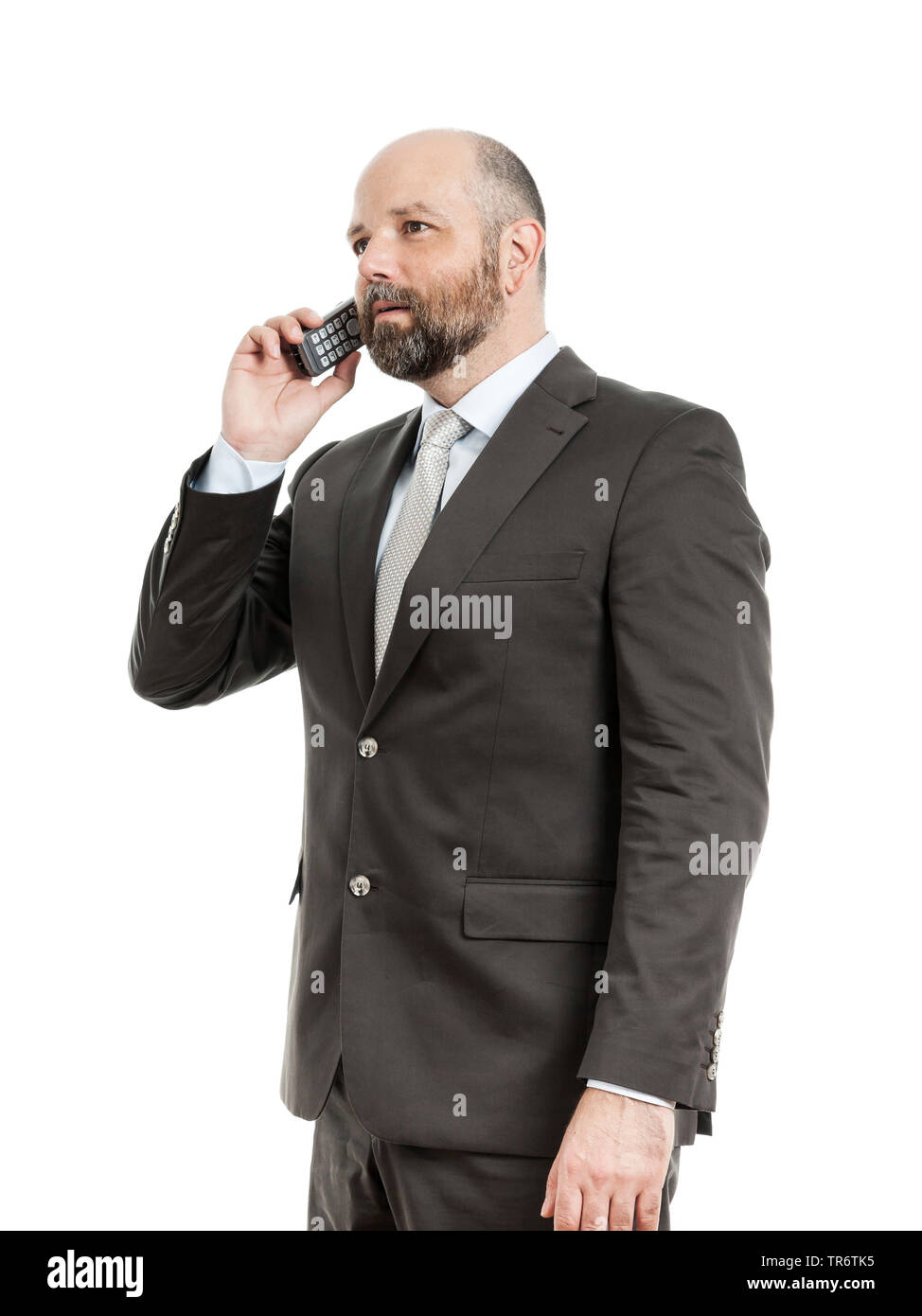 Middle-aged businessmann calling with his phone near his ear, Germany ...