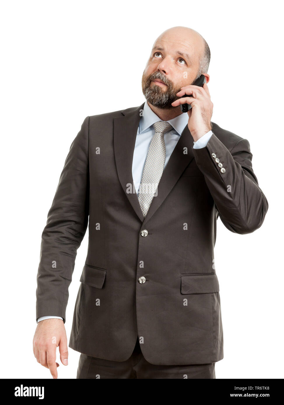 Middle-aged businessmann calling with his phone near his ear, Germany ...
