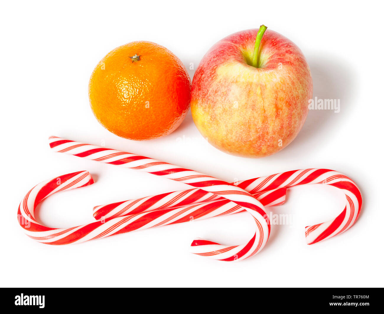 red and white candy canes with an apple and a clementine Stock Photo ...