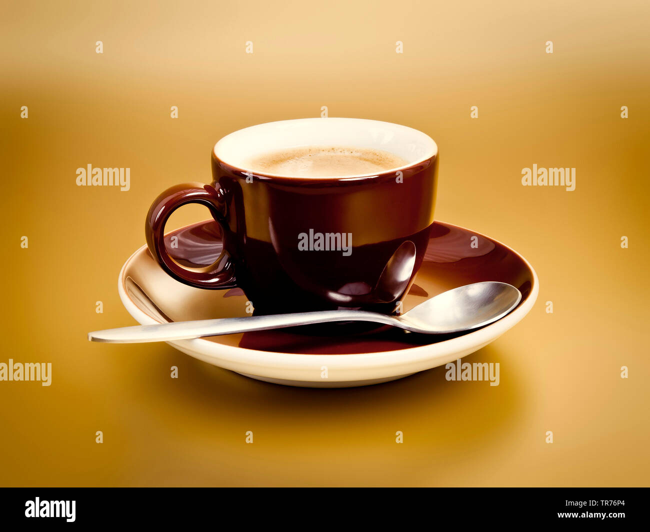 brown cup of coffee on golden background Stock Photo - Alamy