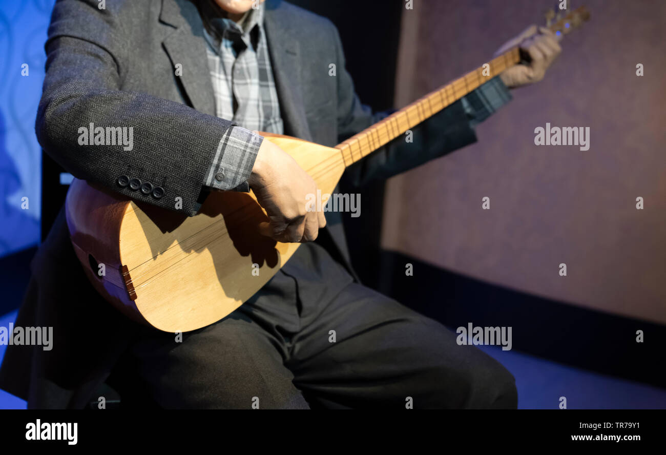 An old man playing Turkish musical instrument baglama in local clothes ...