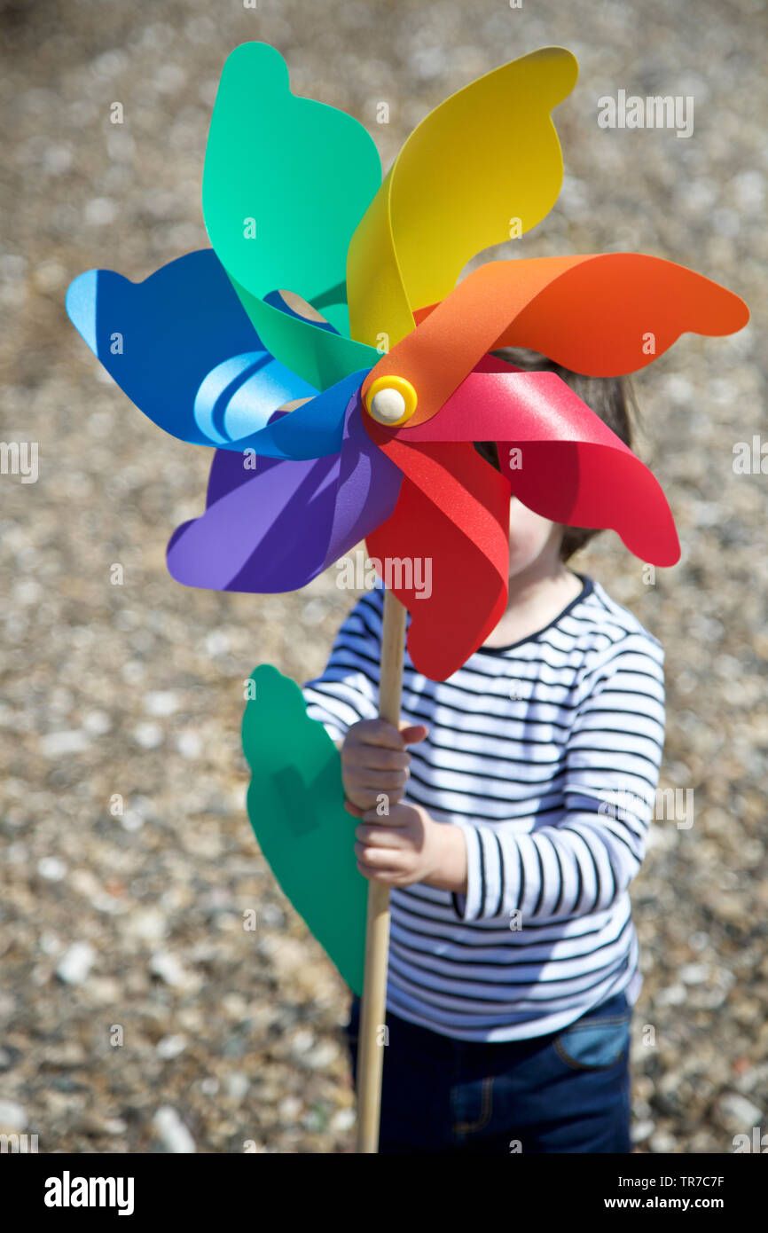 Child holding a colored pinwheel outdoor Stock Photo - Alamy