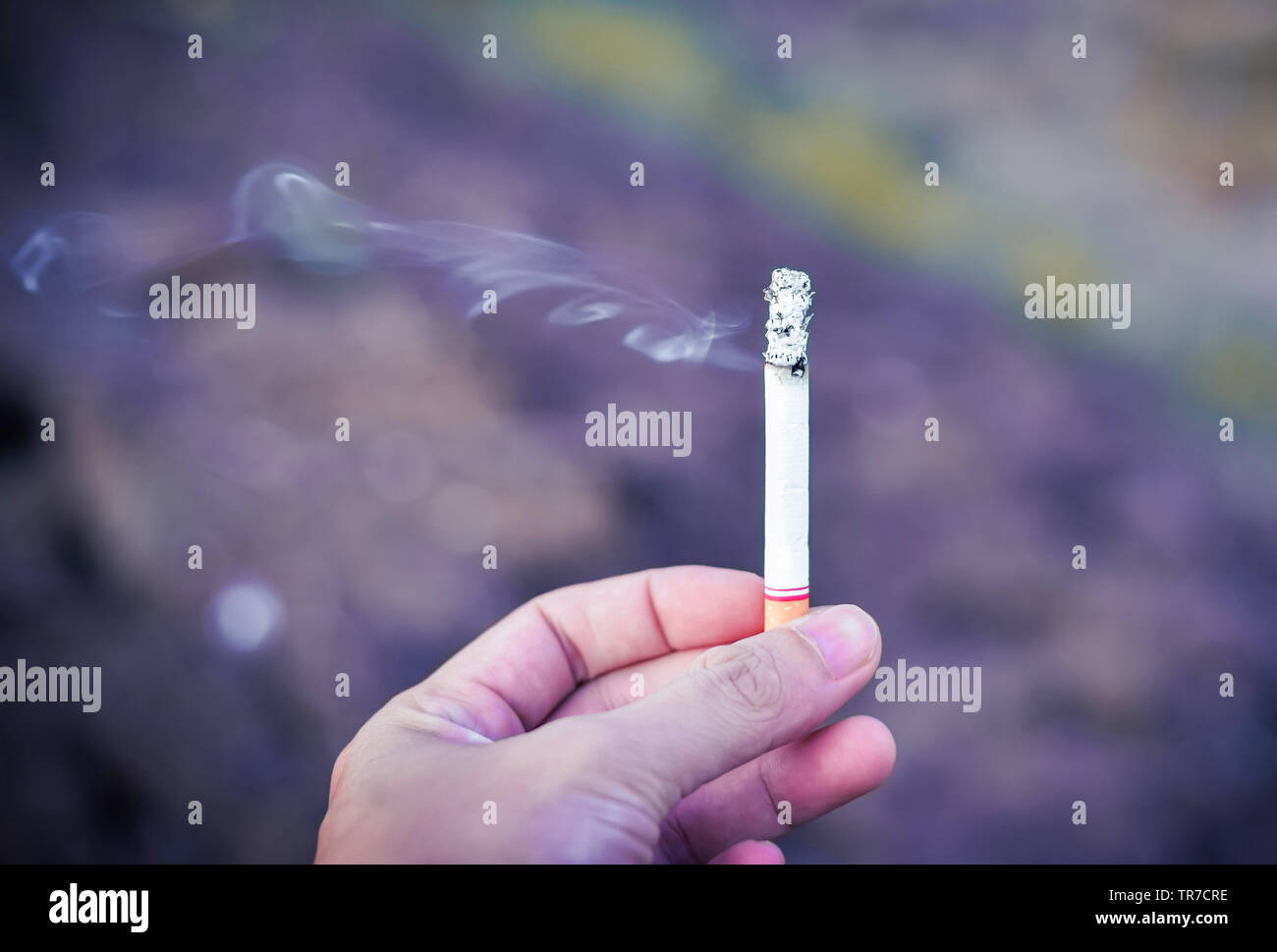 Cigarette smoke burning on hand man smoking on outdoors background ...