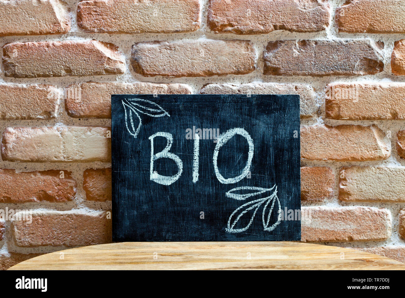 Chalk board with the word BIO drown by hand and chalks on wooden table ...