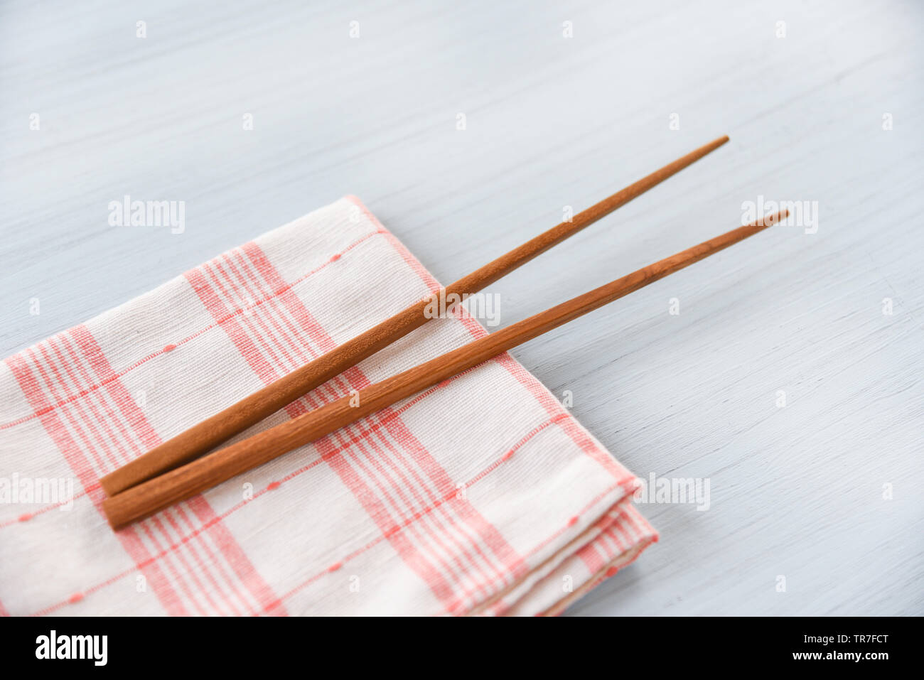 Wooden chopsticks kitchenware set on napery on dining table / Zero ...