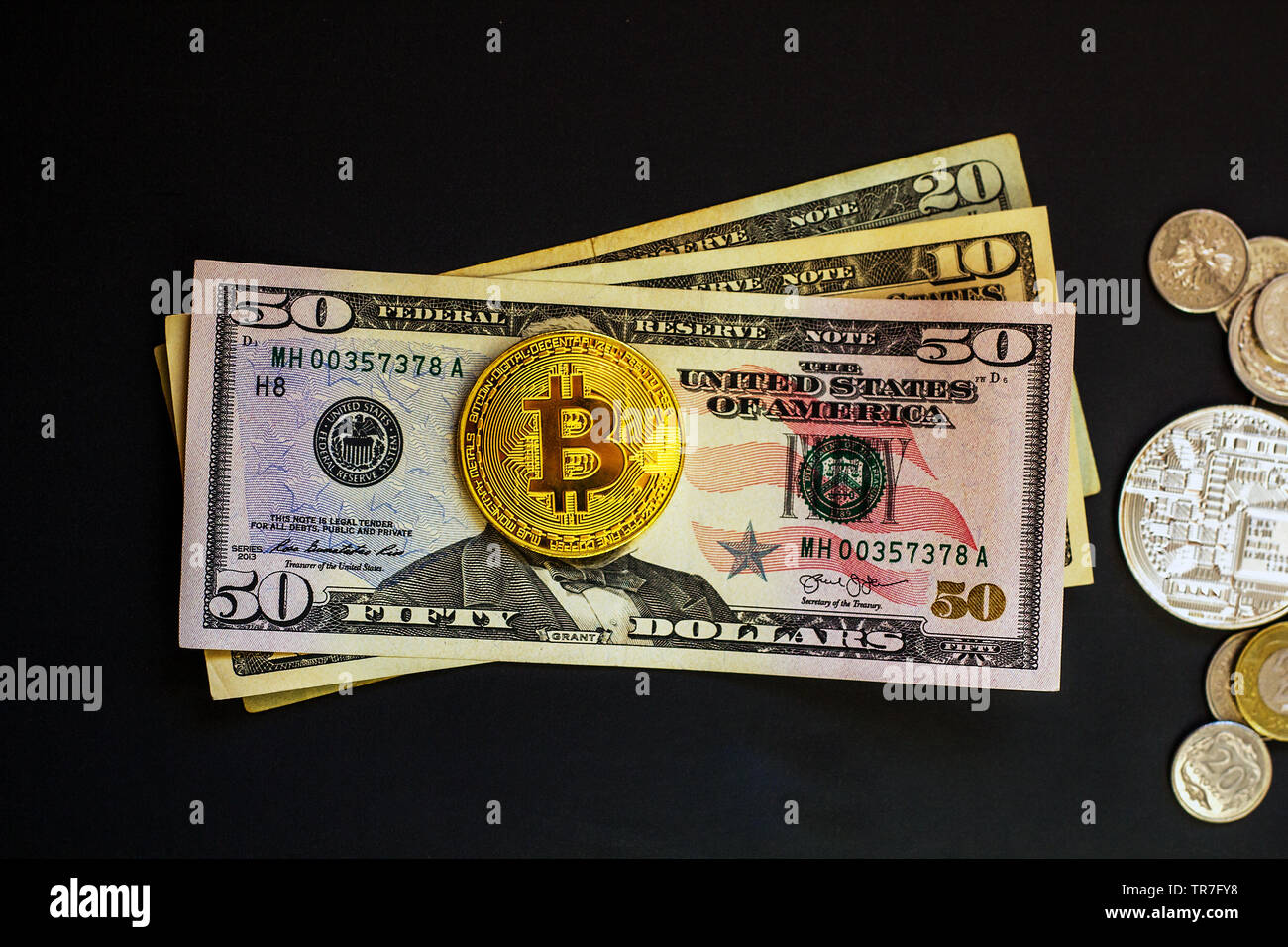 Dollars banknotes and golden bitcoin coin isolated on black background ...