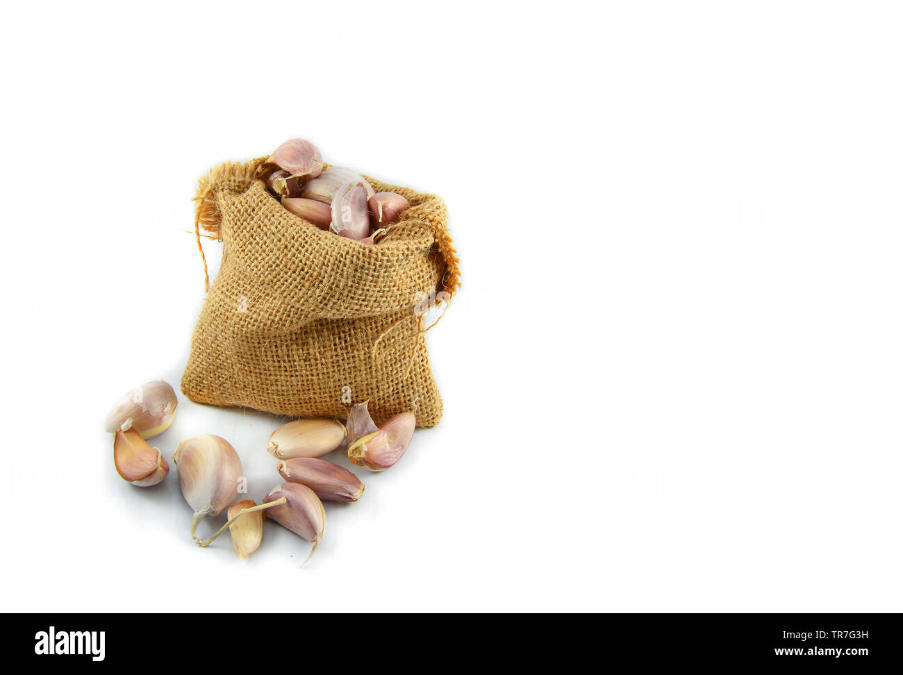 garlic in sack isolated on white background Stock Photo - Alamy