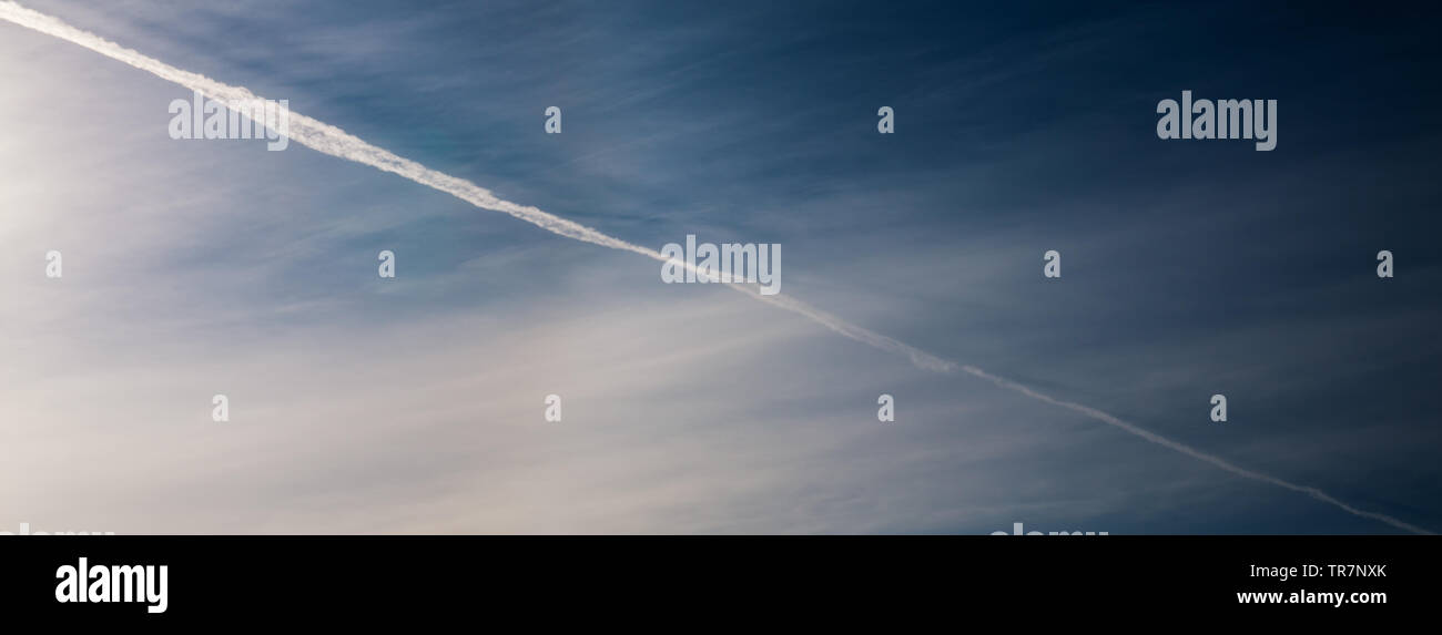 Engine exhaust contrails in the blue sky Stock Photo - Alamy