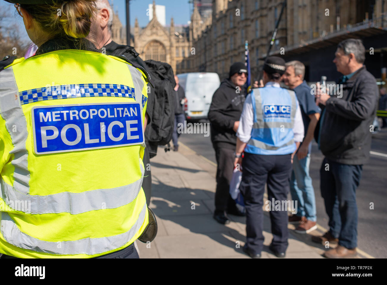 Police Officer in the foreground, watches on as a Police Liaison ...