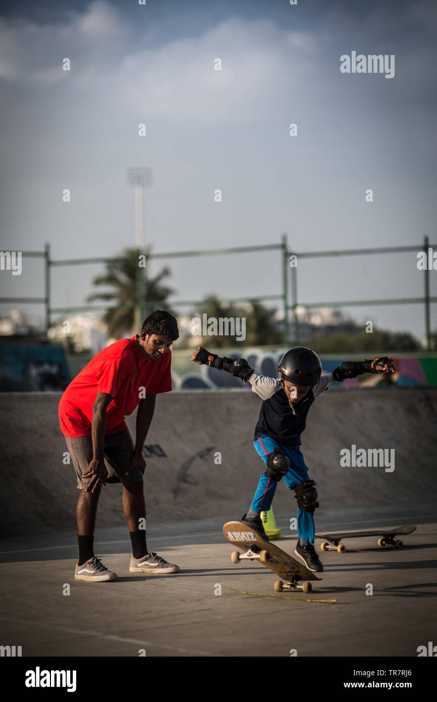 A child being coached while skateboarding in a skatepark in Bangalore ...