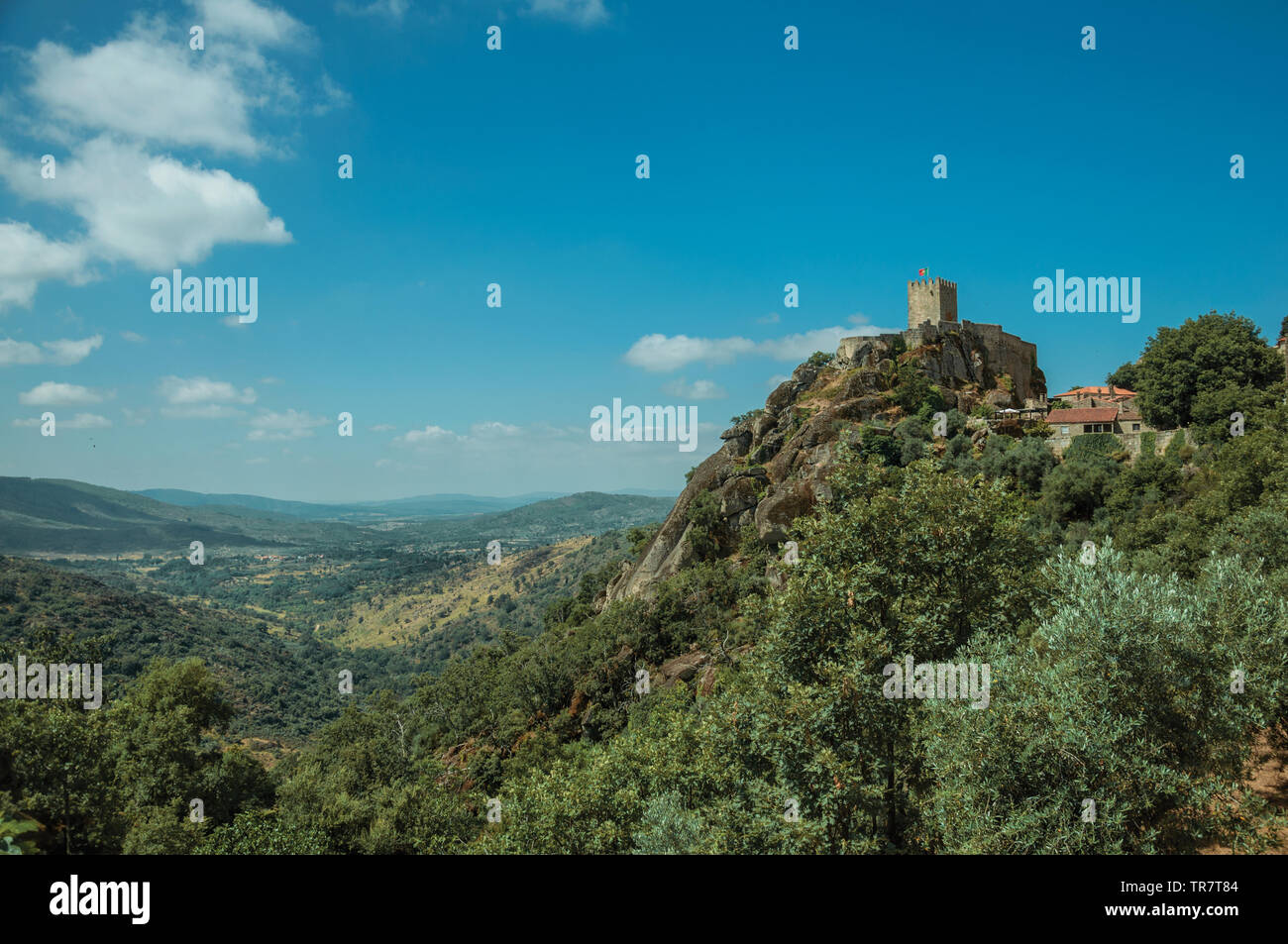 Hilly landscape with stone walls and tower of Castle on rocky cliff at ...