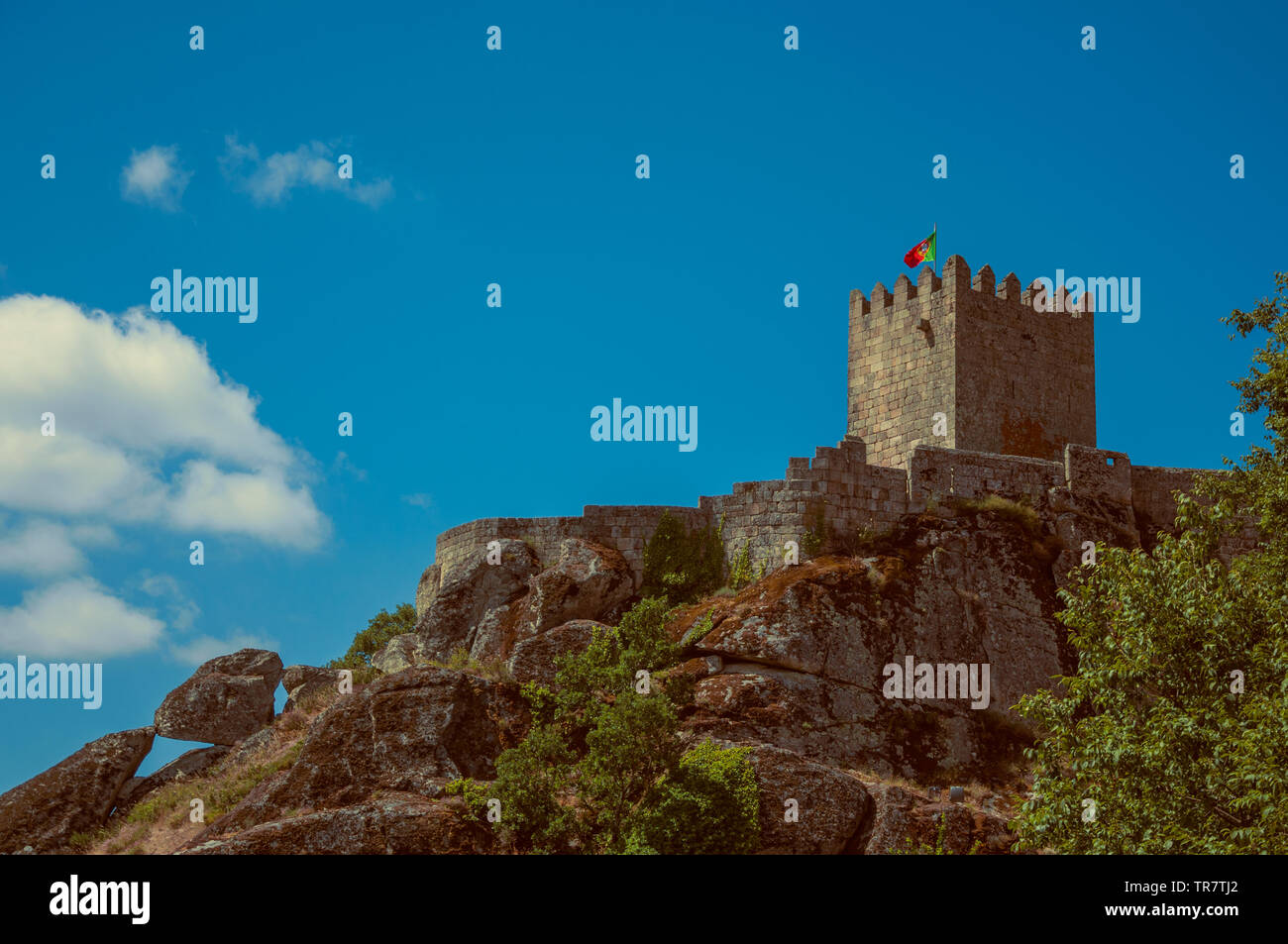 Hilly landscape with stone walls and tower of Castle over rocky cliff ...