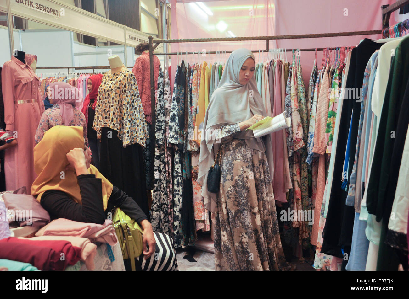 A booth keeper takes a note at Indonesia Moslem Fashion Expo. Muslim ...