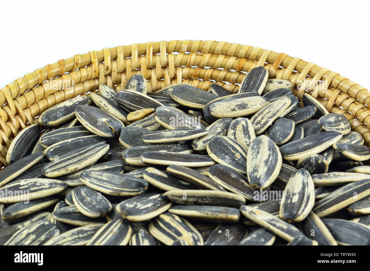 Close up of sunflower seeds in basket for snack isolated on white ...