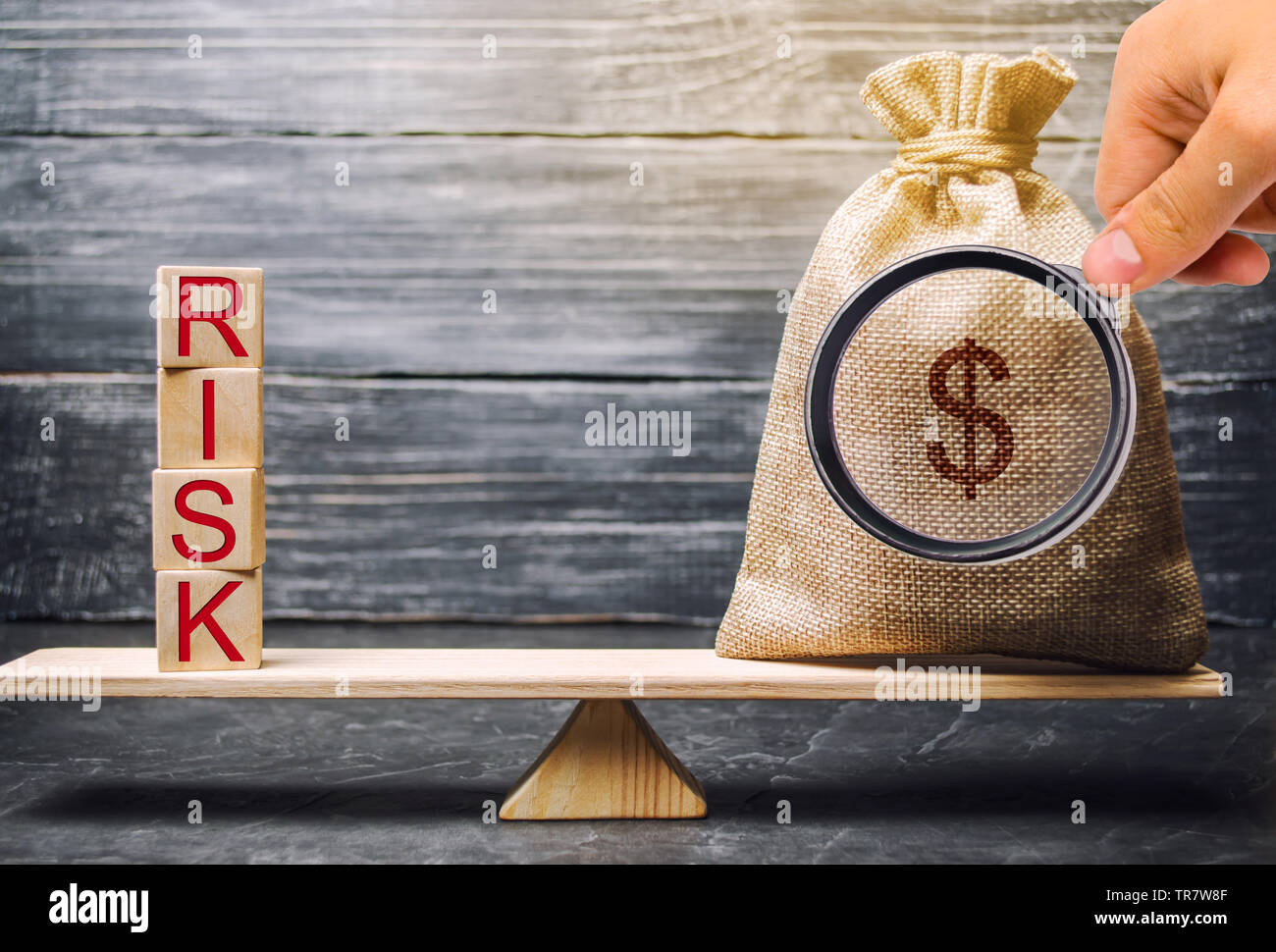 Money bag and wooden blocks with the word Risk. The concept of ...