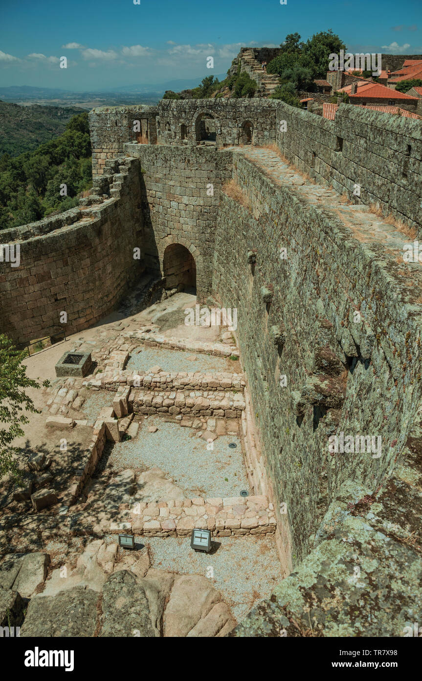 Pathway on stone wall with front gate and hilly landscape at the ...