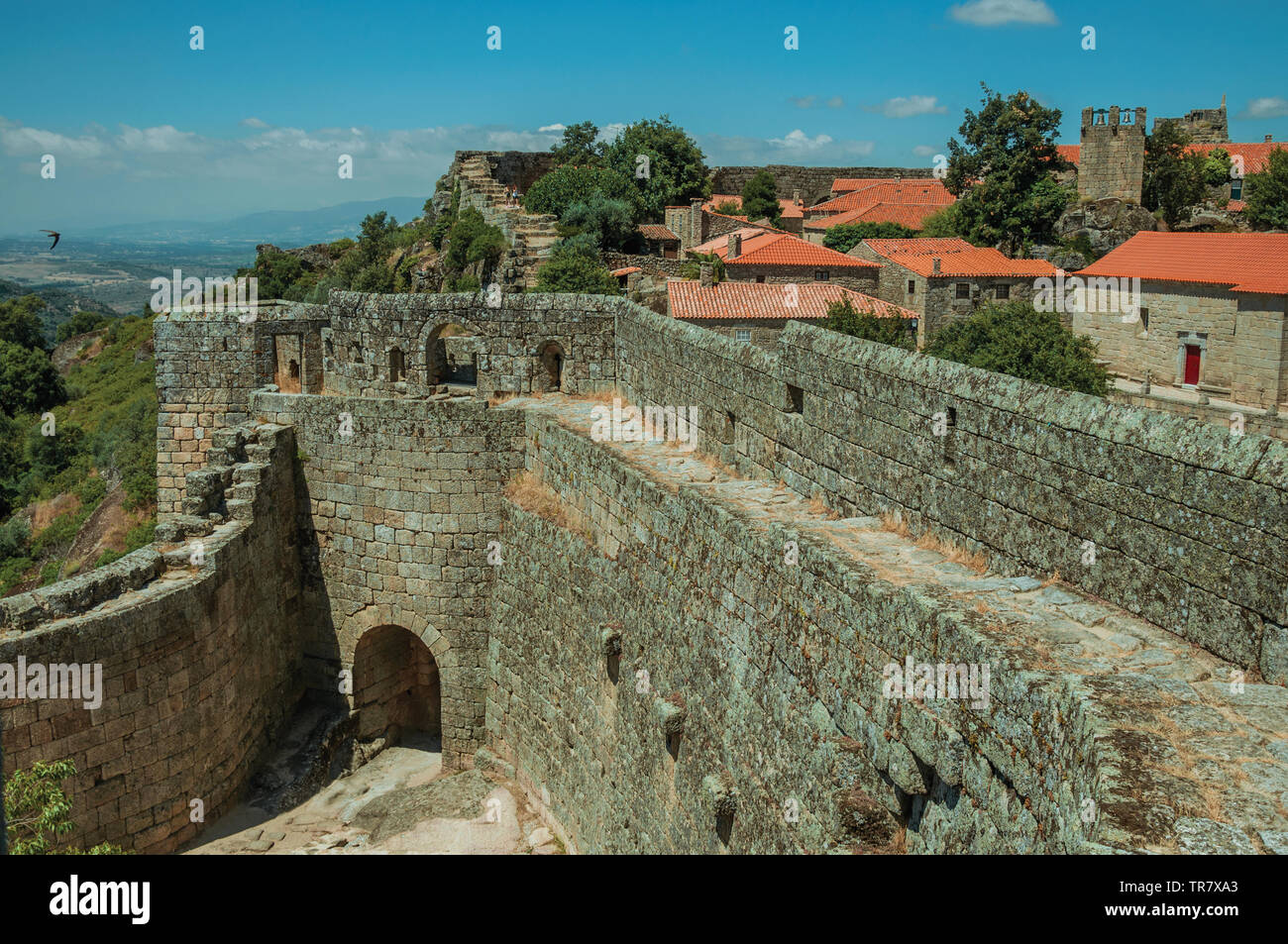 Pathway on stone wall with front gate and hilly landscape at the ...