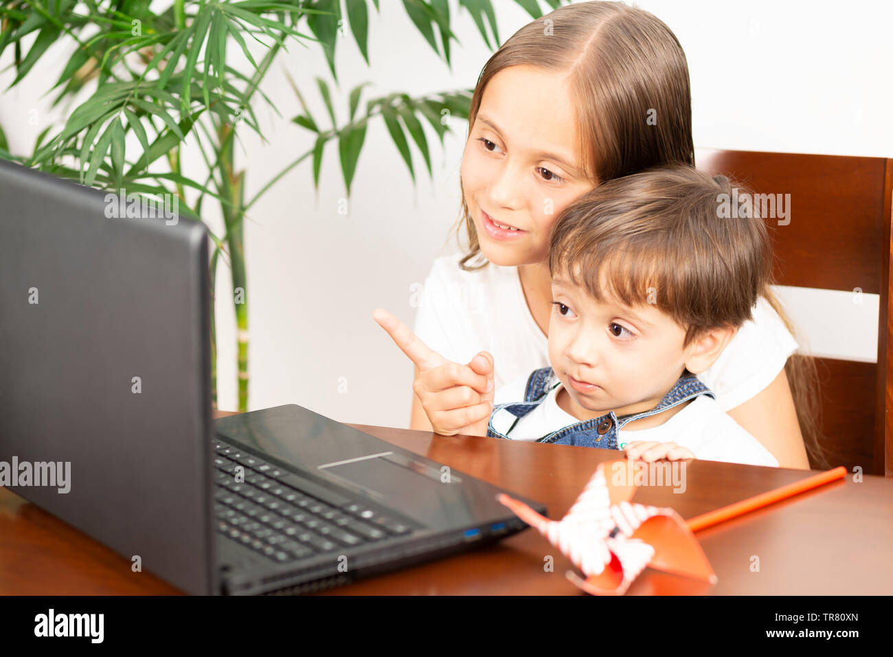 Happy Girl and Boy Sitting at his Desk With Laptop Computer Stock Photo ...