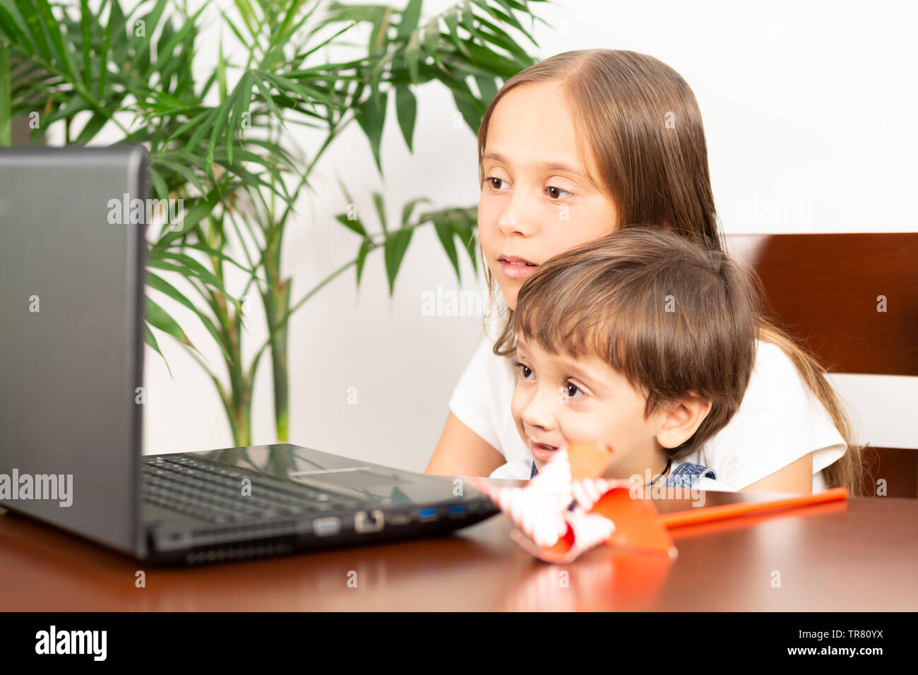 Happy Girl and Boy Sitting at his Desk With Laptop Computer Stock Photo ...