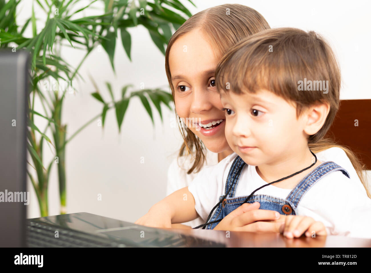 Happy Girl and Boy Sitting at his Desk With Laptop Computer Stock Photo ...