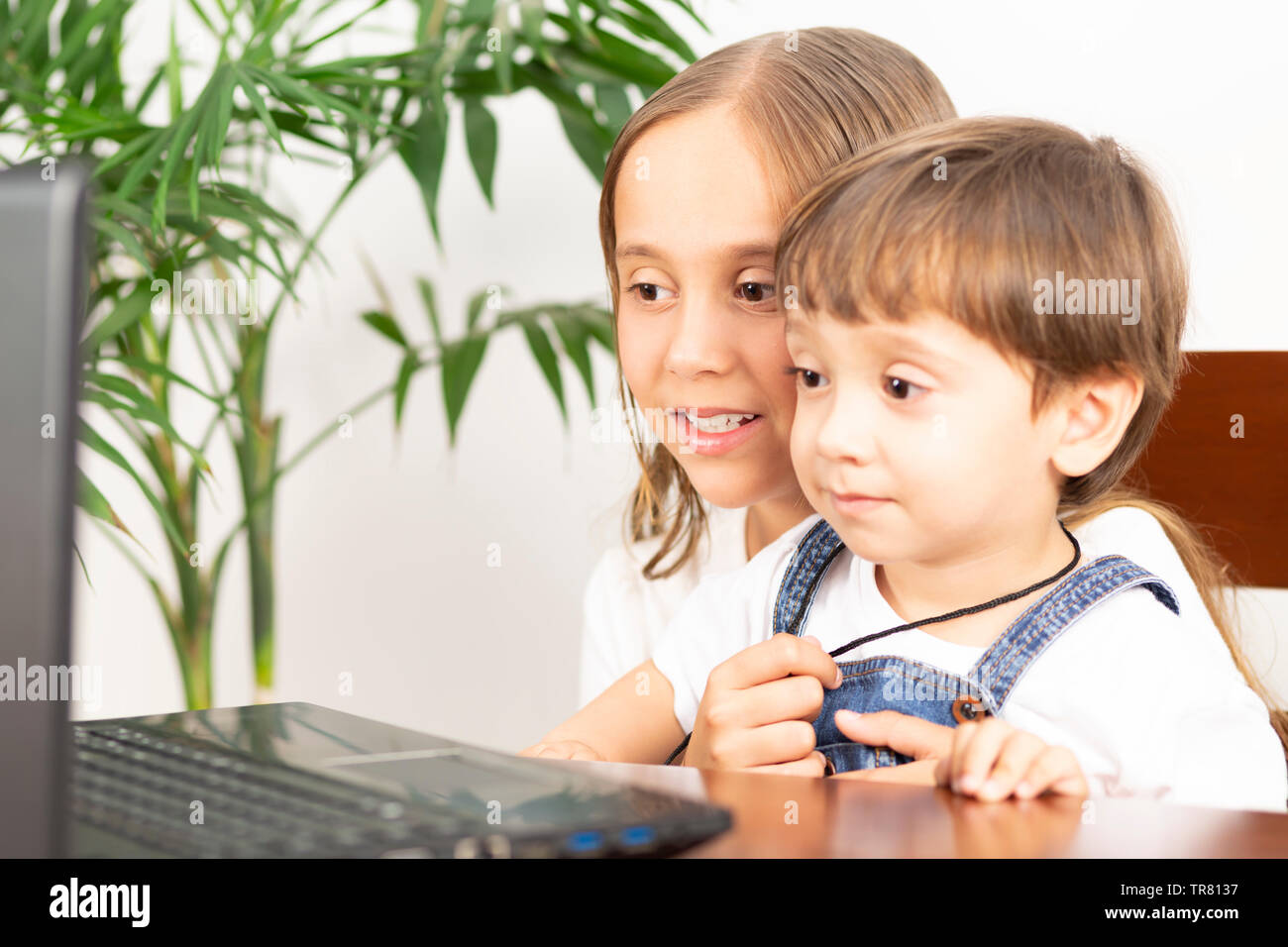 Happy Girl and Boy Sitting at his Desk With Laptop Computer Stock Photo ...