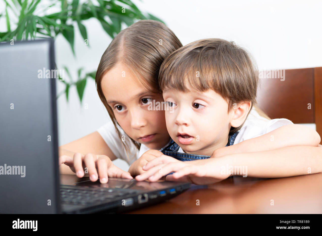 Happy Girl and Boy Sitting at his Desk With Laptop Computer Stock Photo ...