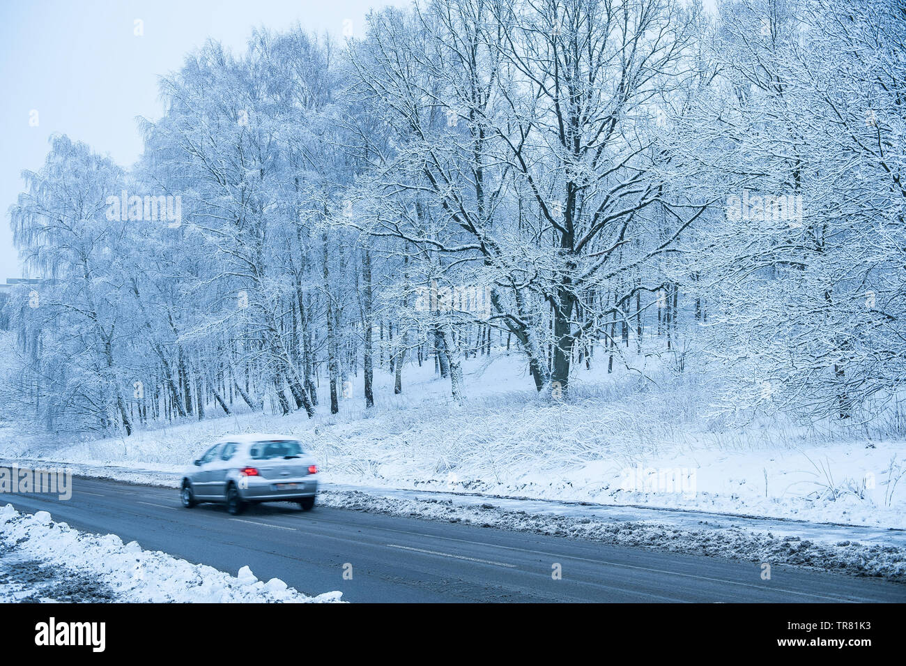 A car driving on a road in a cold, snowy landscape Stock Photo - Alamy