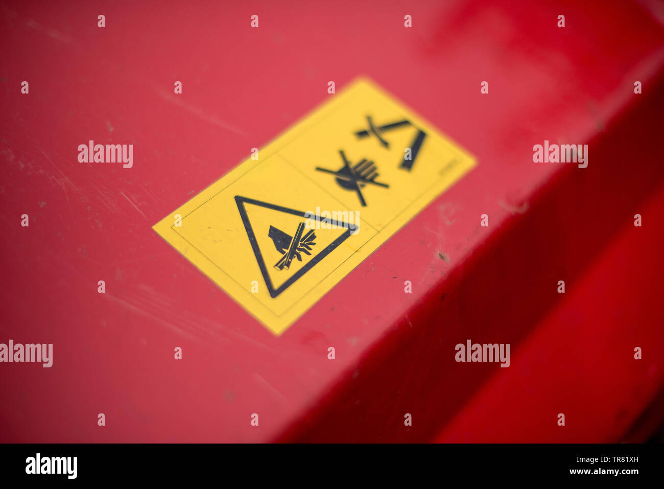 Yellow warning label on a red lawn mower Stock Photo - Alamy