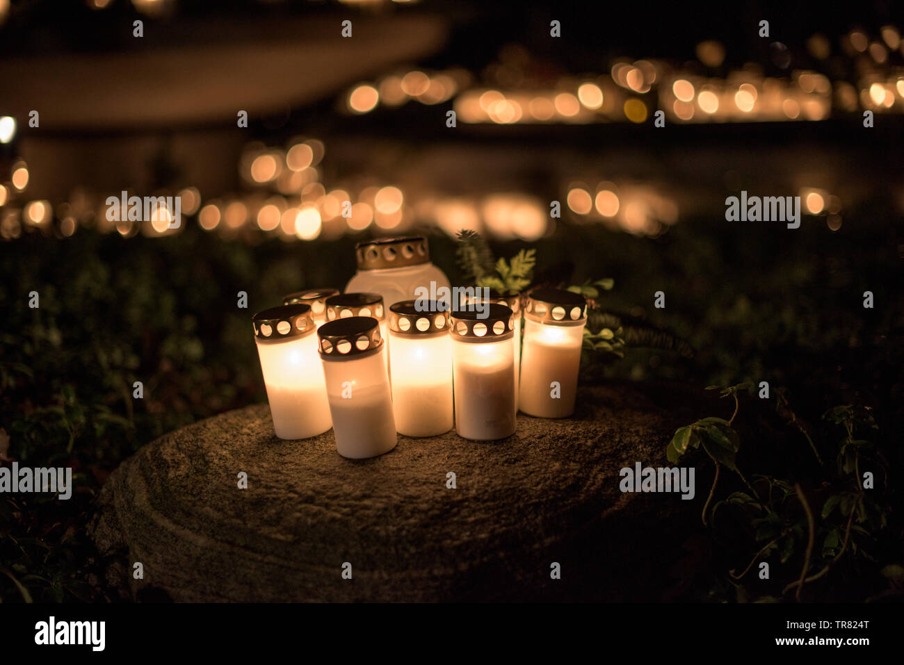 lit candles on a stone at a graveyard Stock Photo - Alamy