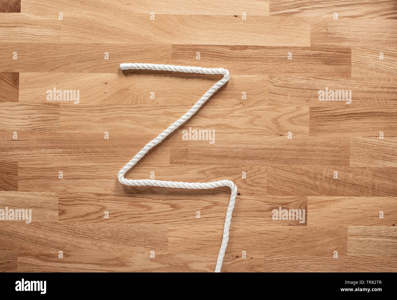 The letter Z formed with white rope on a wooden table Stock Photo - Alamy
