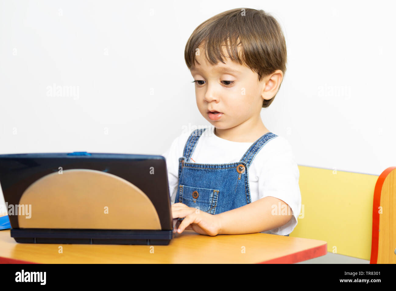 Happy Boy Sitting at his Desk With Laptop Computer Stock Photo - Alamy