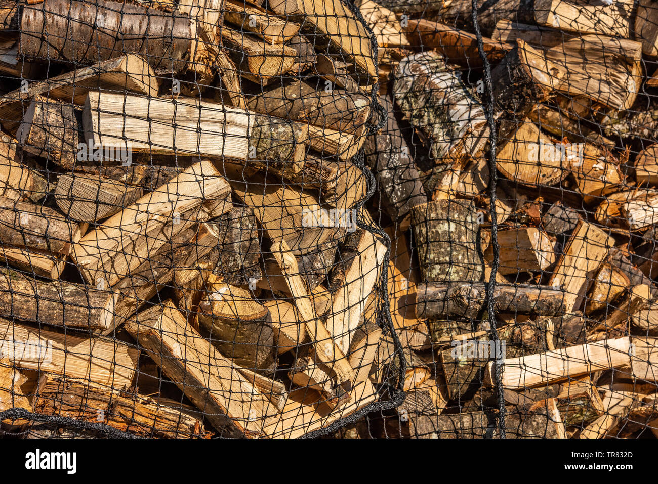 Chopped wood loaded into nets Stock Photo - Alamy