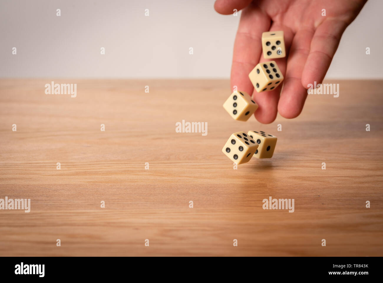 Hand throwing dice in front of a dark background Stock Photo - Alamy