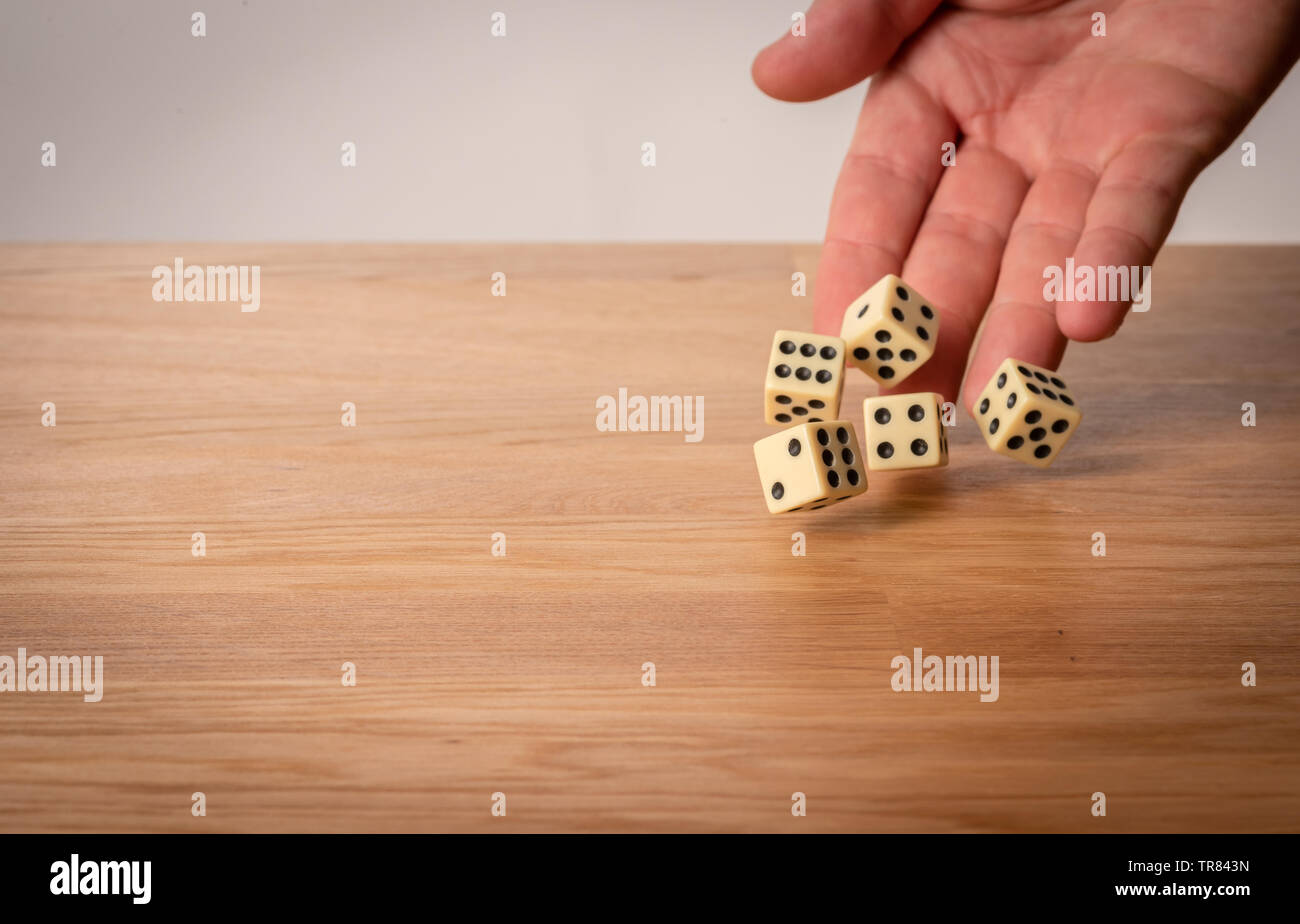 Hand throwing dice in front of a dark background Stock Photo - Alamy