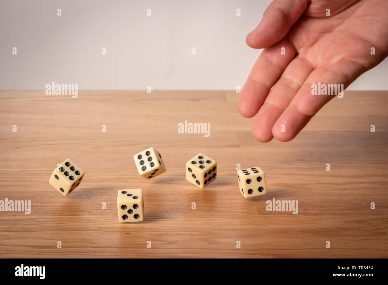 Hand throwing dice in front of a dark background Stock Photo - Alamy