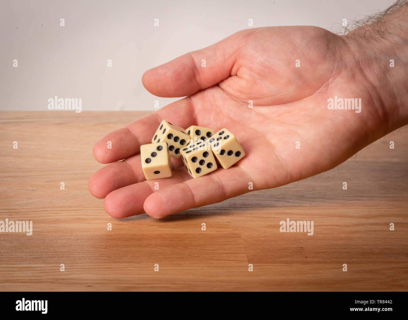 Hand throwing dice in front of a dark background Stock Photo - Alamy