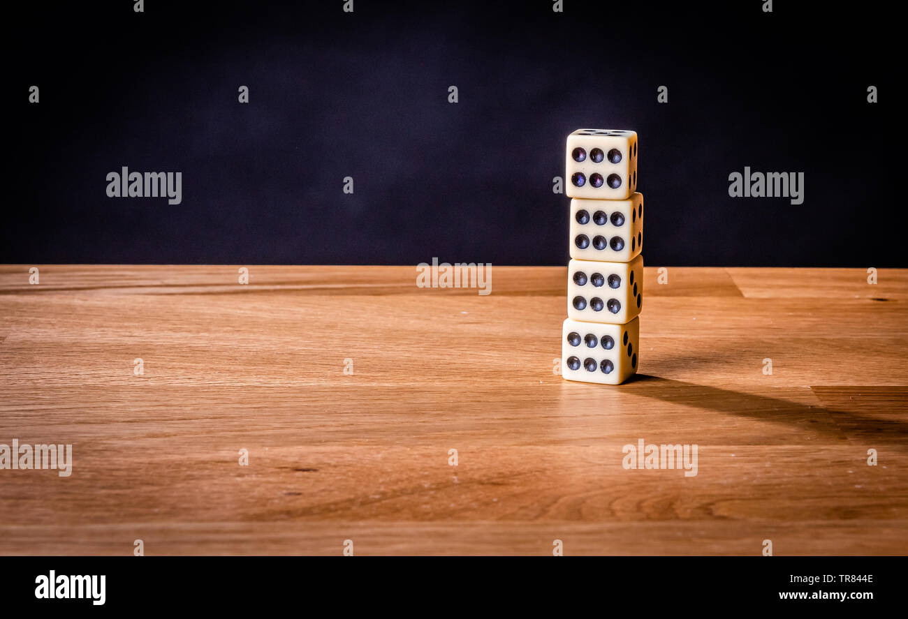 A stack of dice on a wooden table against a black background Stock ...