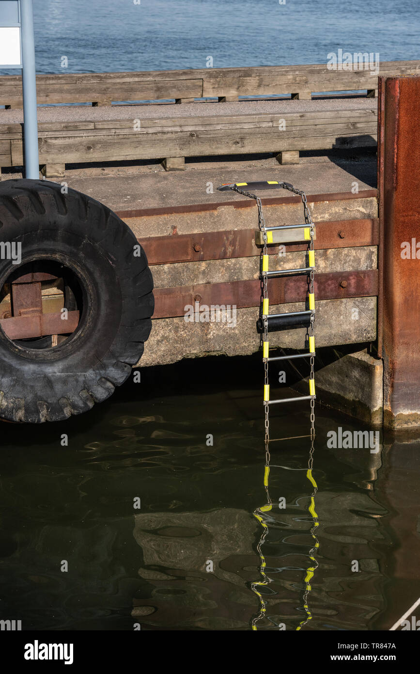 Tyre and rescue ladder on a pier by the river Stock Photo - Alamy