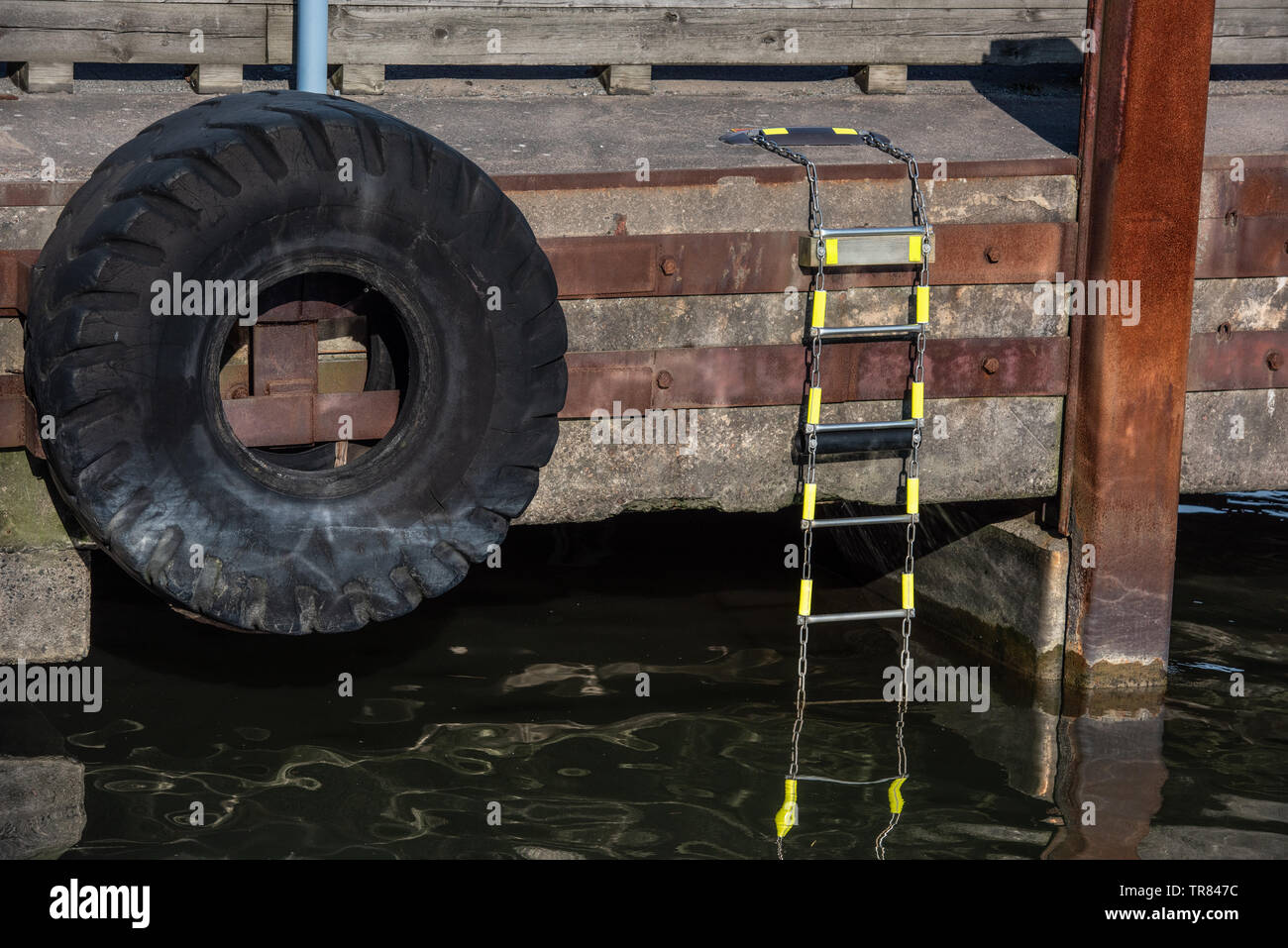 Tyre and rescue ladder on a pier by the river Stock Photo - Alamy