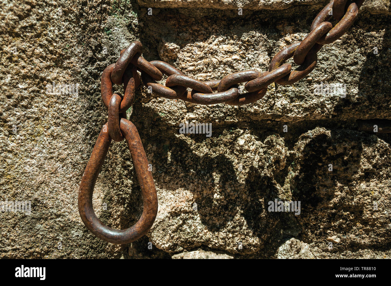 Iron chain stuck in a stone brick wall on a gothic house at Sortelha ...