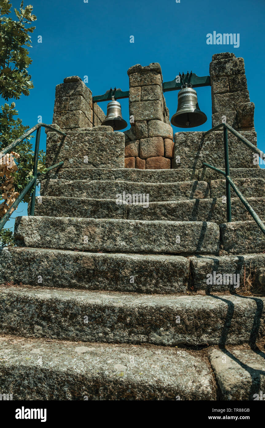 Stone staircase with iron railing and bronze bells on top, in a sunny ...