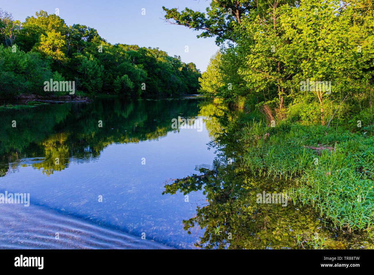 The water of Spring Creek flowing over the concrete slab bridge located ...