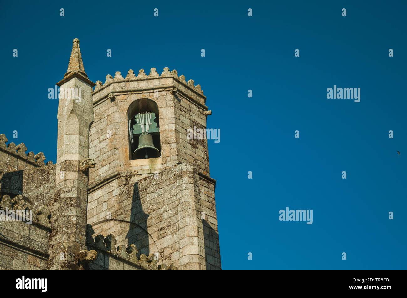 Steeple with stone brick and bronze bell on the gothic Guarda Cathedral ...