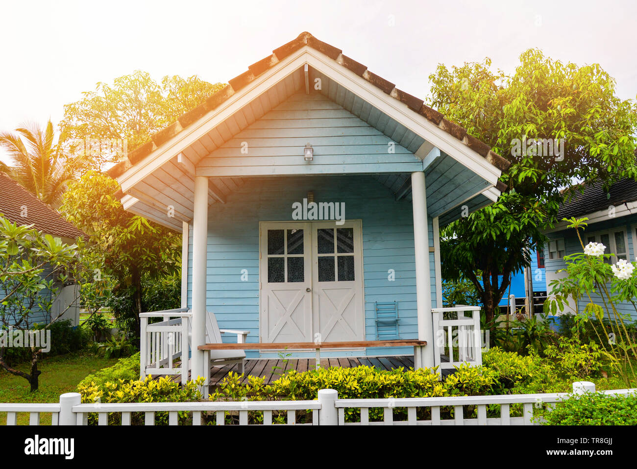 little blue house cottage in the garden summer green plant and tree ...