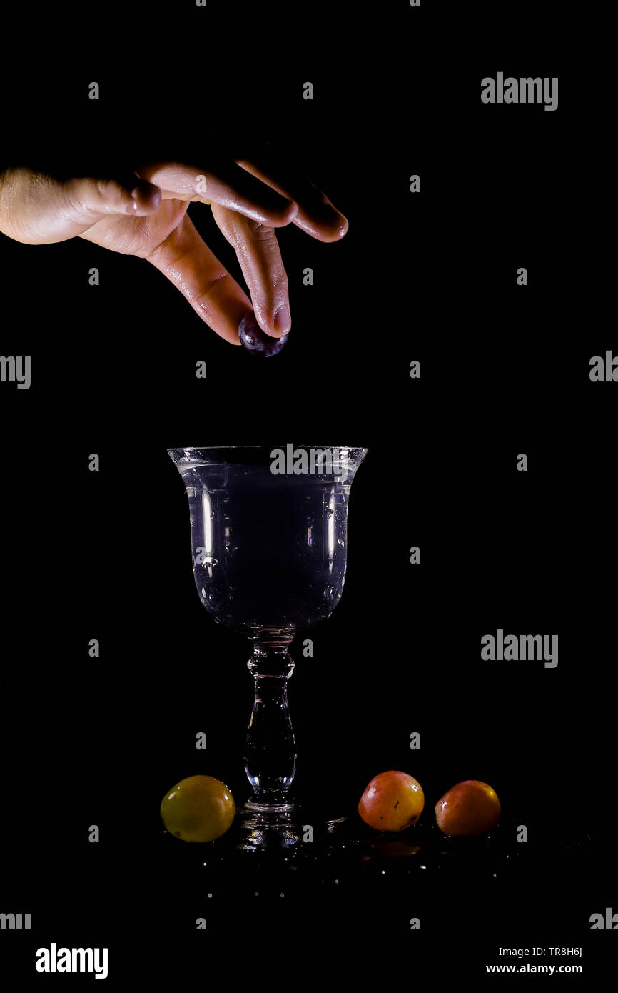 throw grapes in a water-filled glass and splash Stock Photo - Alamy